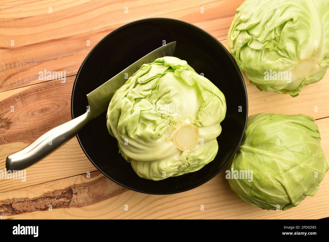 Three tasty juicy natural cabbage with a black plate and knife, close ...