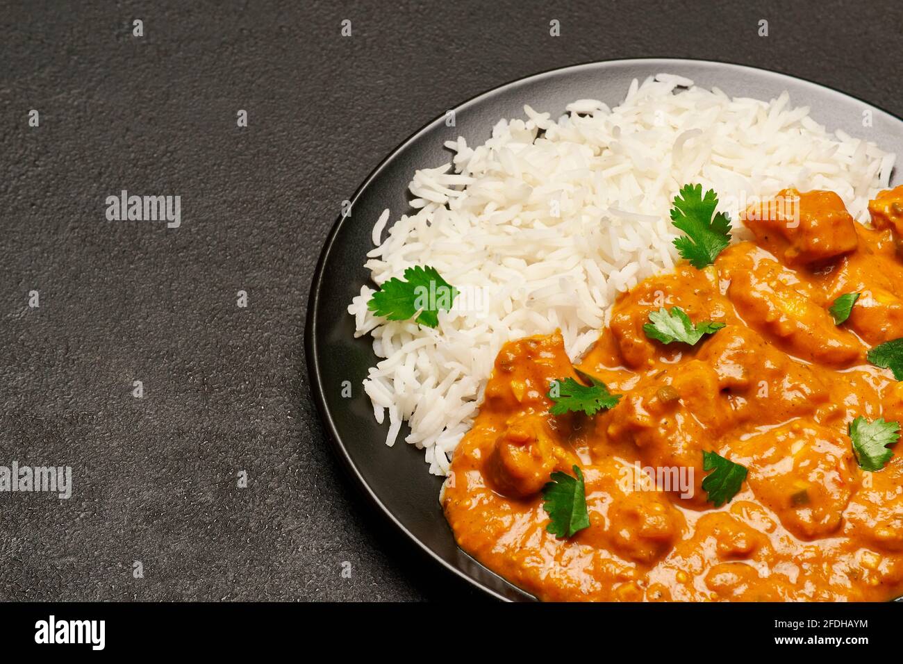 Plate of Traditional Chicken Curry and rice on dark concrete background ...