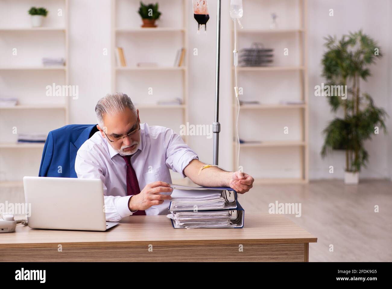 Old businessman employee in blood transfusion concept Stock Photo - Alamy