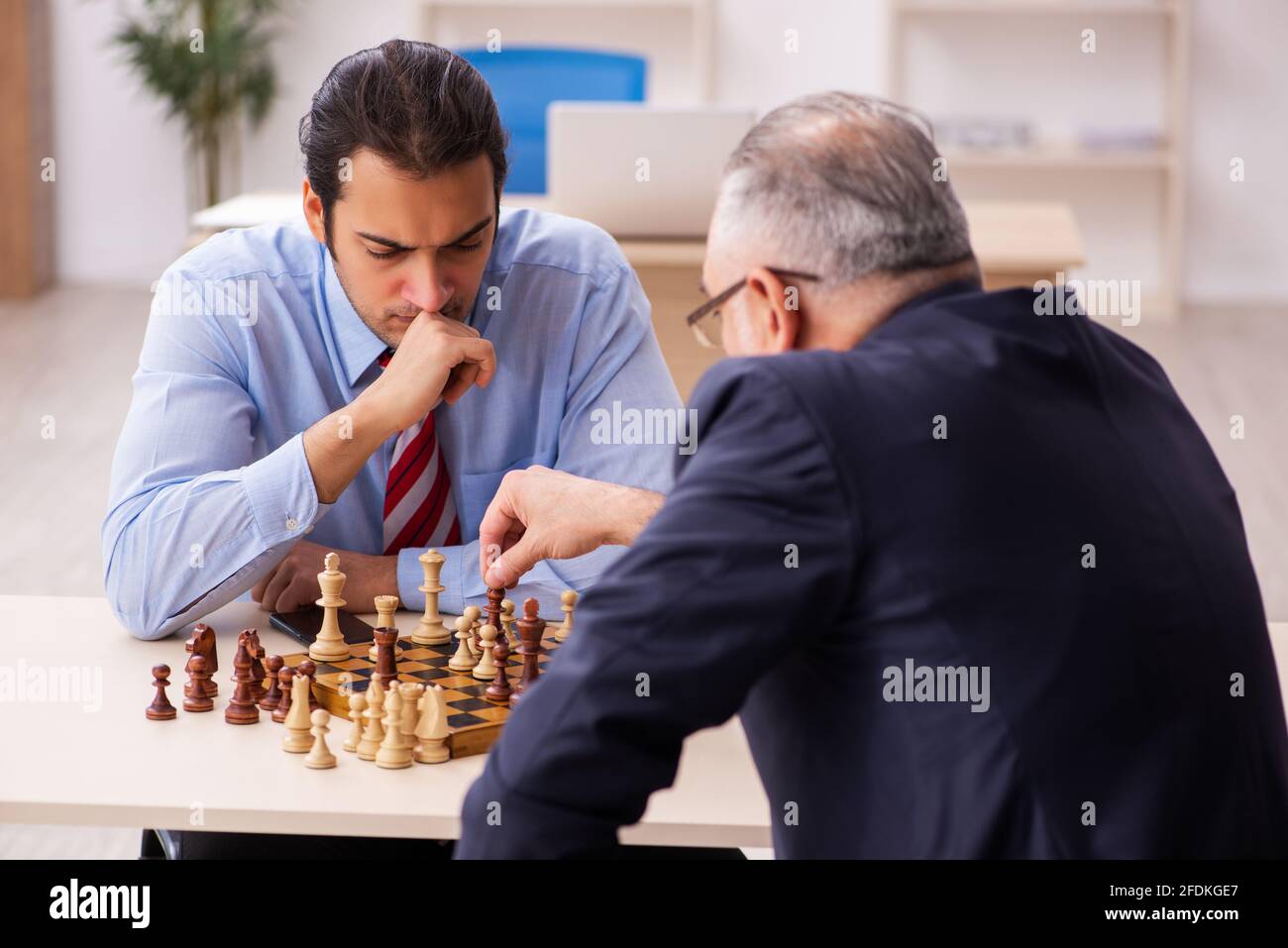 Two male employees playing chess at workplace Stock Photo - Alamy