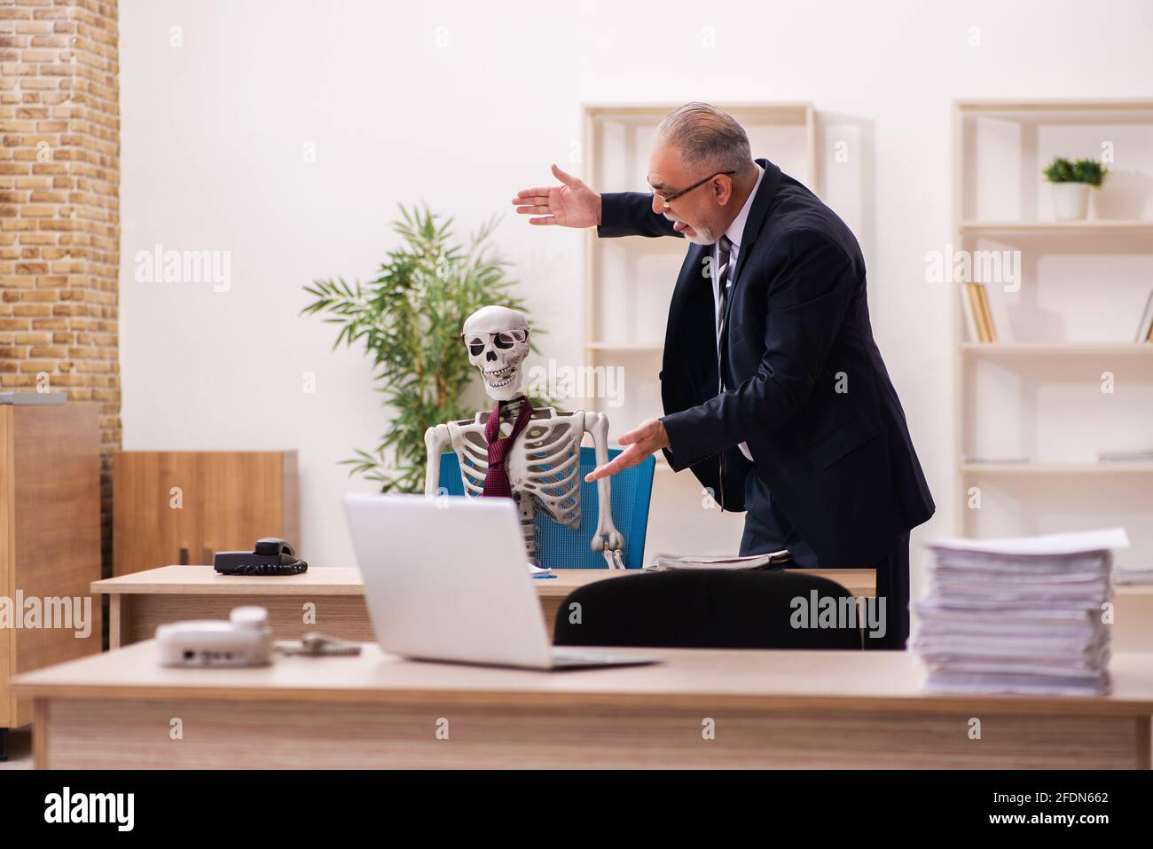 Dead employee working in the office in funny concept Stock Photo - Alamy