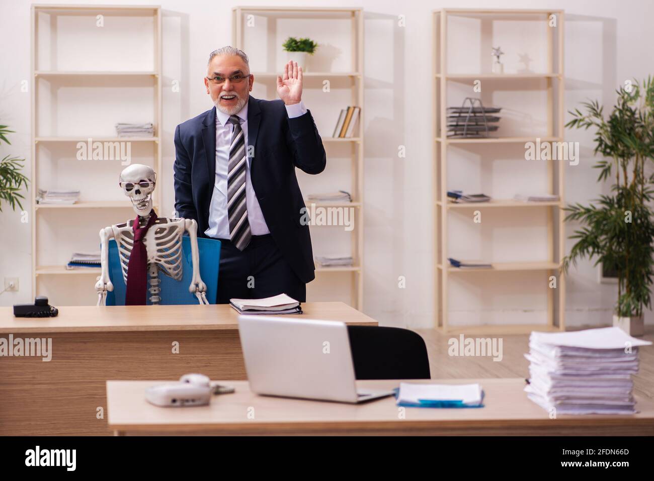 Dead employee working in the office in funny concept Stock Photo - Alamy
