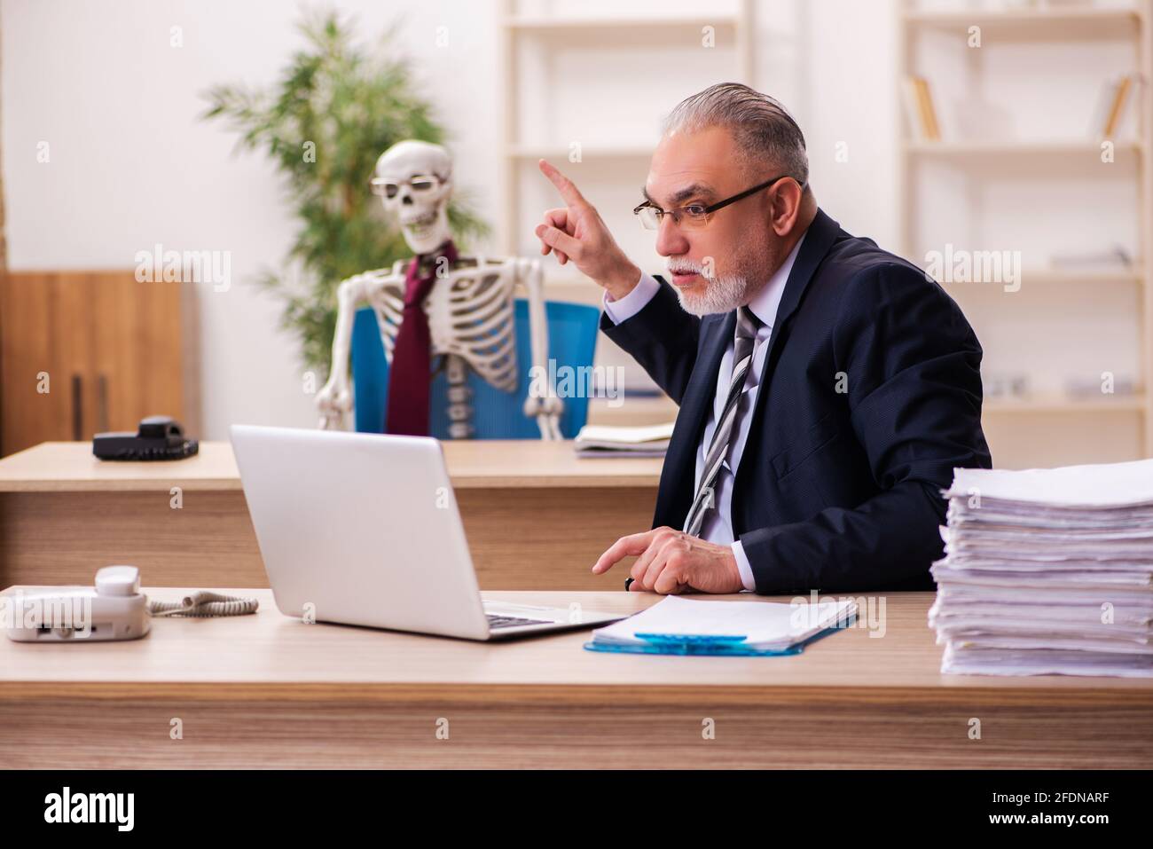 Dead employee working in the office in funny concept Stock Photo - Alamy