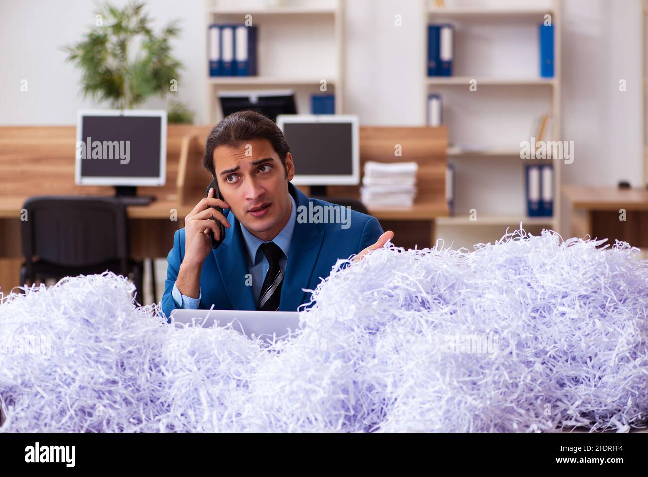 Young businessman employee and a lot of cut papers in the office Stock ...