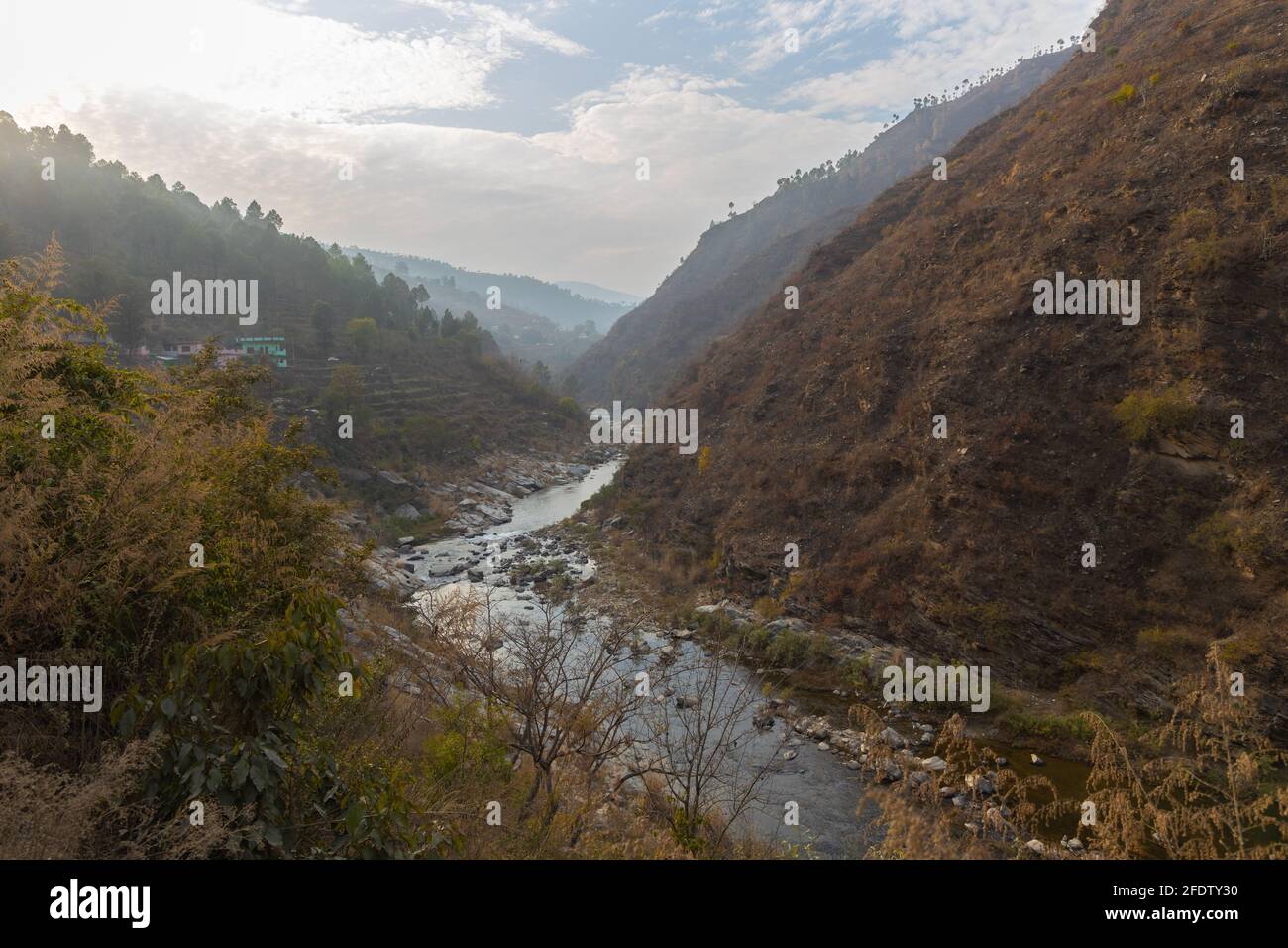 A view of a river flowing through a narrow valley with stones and rocks ...