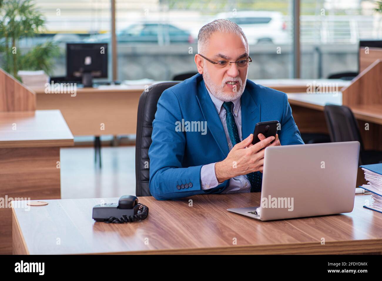 Old employee working in the office Stock Photo - Alamy