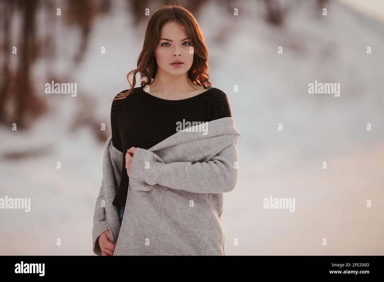 Young beautiful Bosnian woman in a jacket posing outdoors in the winter ...