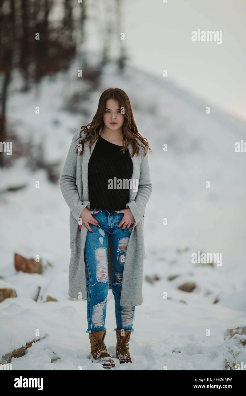 Young beautiful Bosnian woman in a jacket posing outdoors in the winter ...