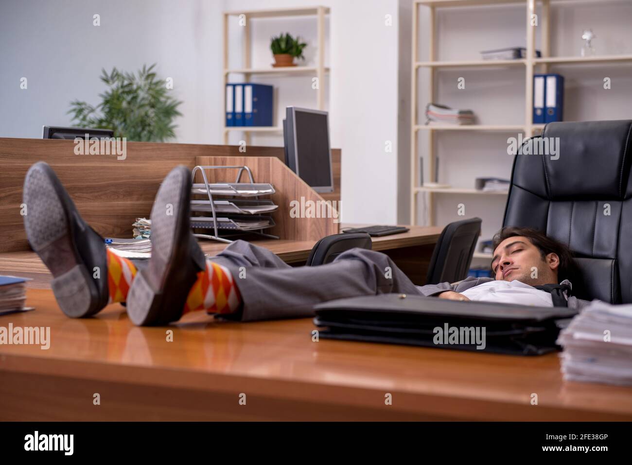 Young employee sleeping at workplace Stock Photo - Alamy