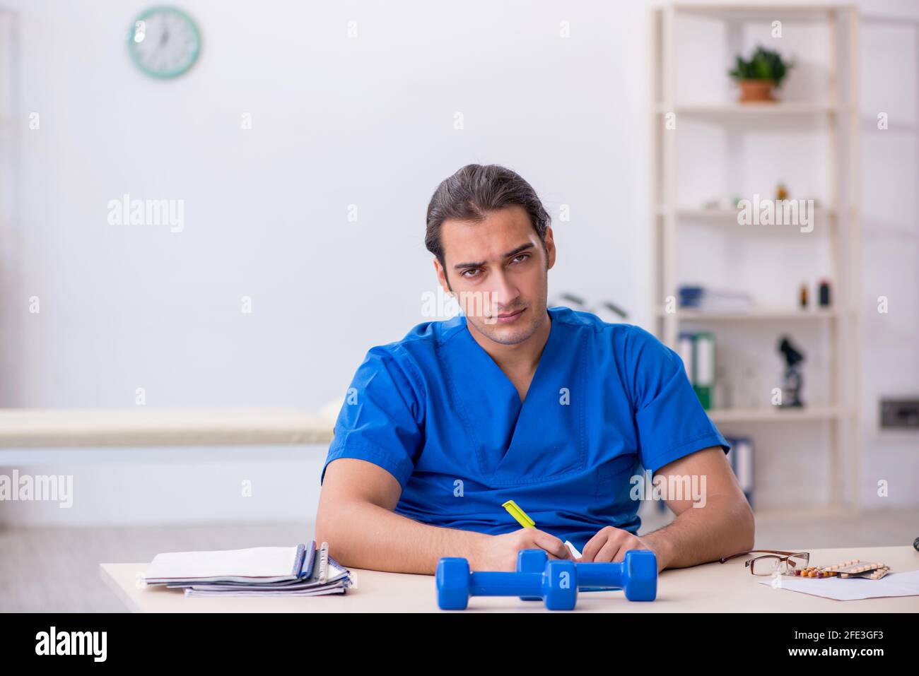 Young doctor physiotherapist doing sport exercises Stock Photo - Alamy