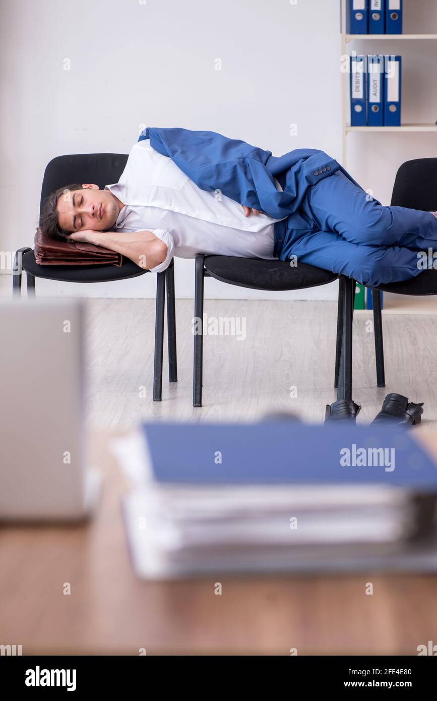 Young employee sleeping in the office on chairs Stock Photo - Alamy
