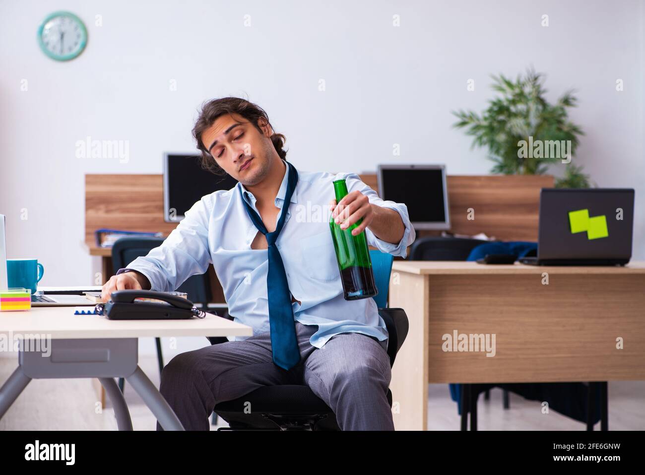 Male employee drinking alcohol at workplace Stock Photo - Alamy