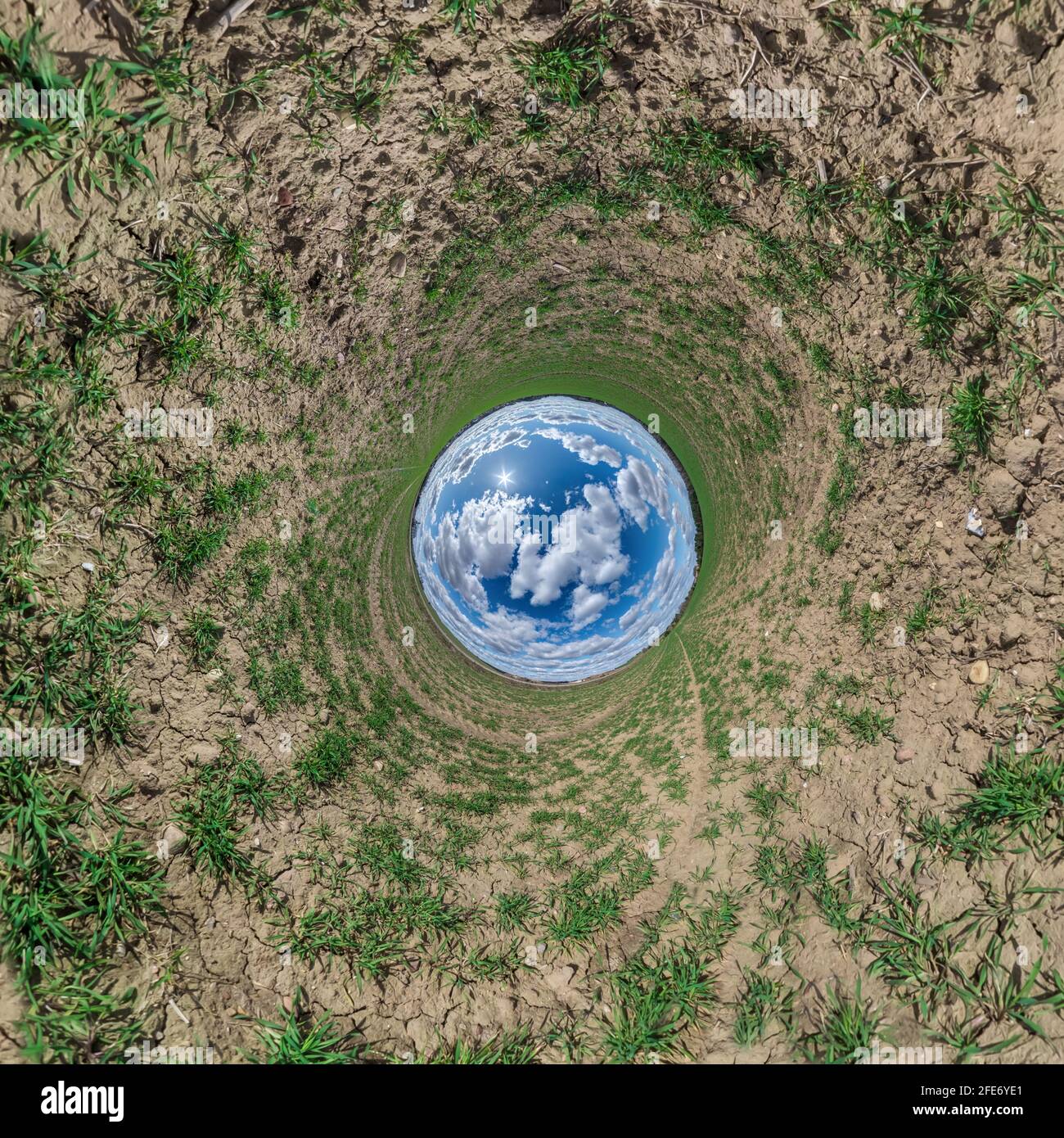 blue sky ball in middle of swirling green field. Inversion of tiny ...