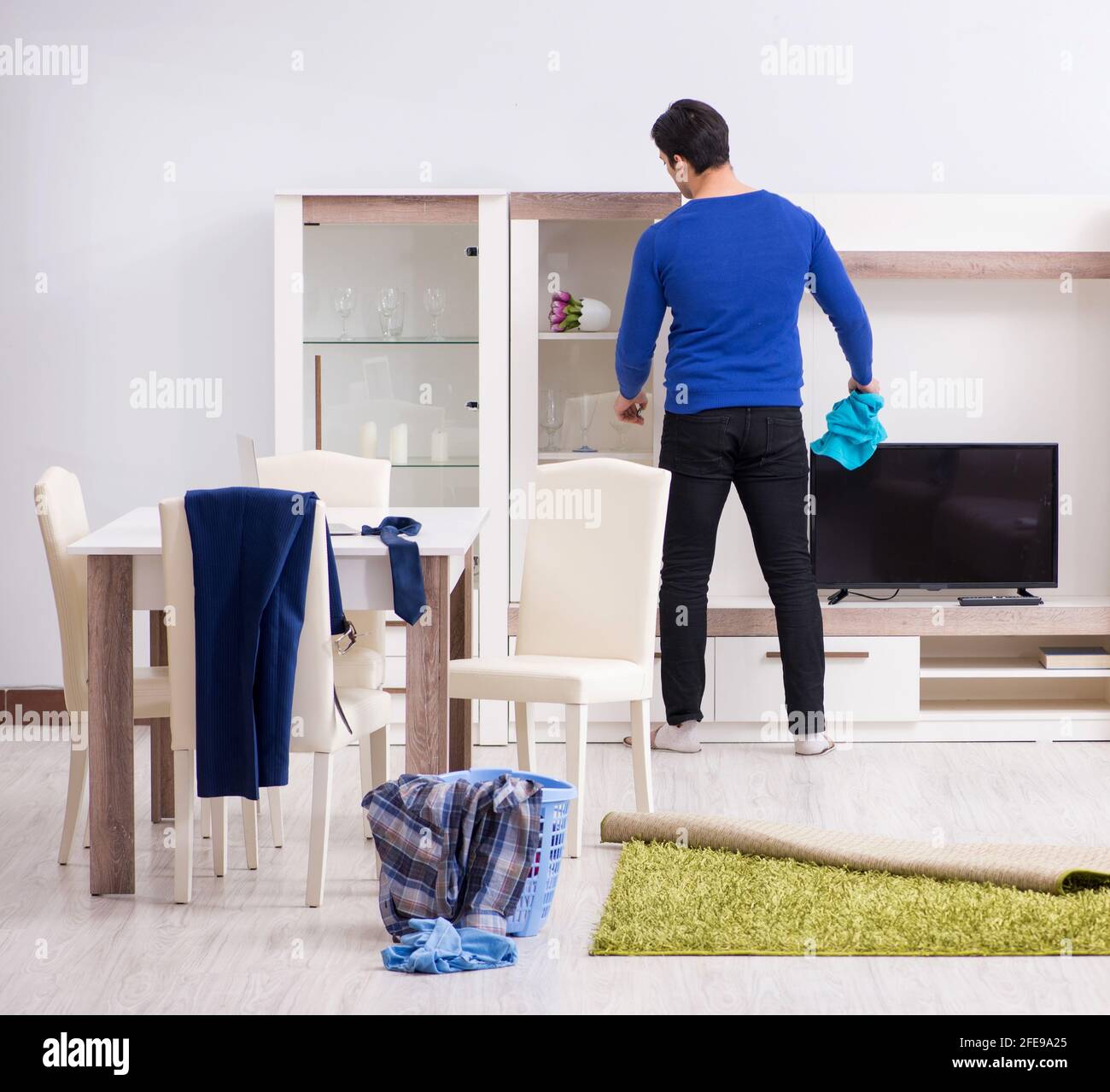 The young man collecting dirty clothing for laundry Stock Photo - Alamy