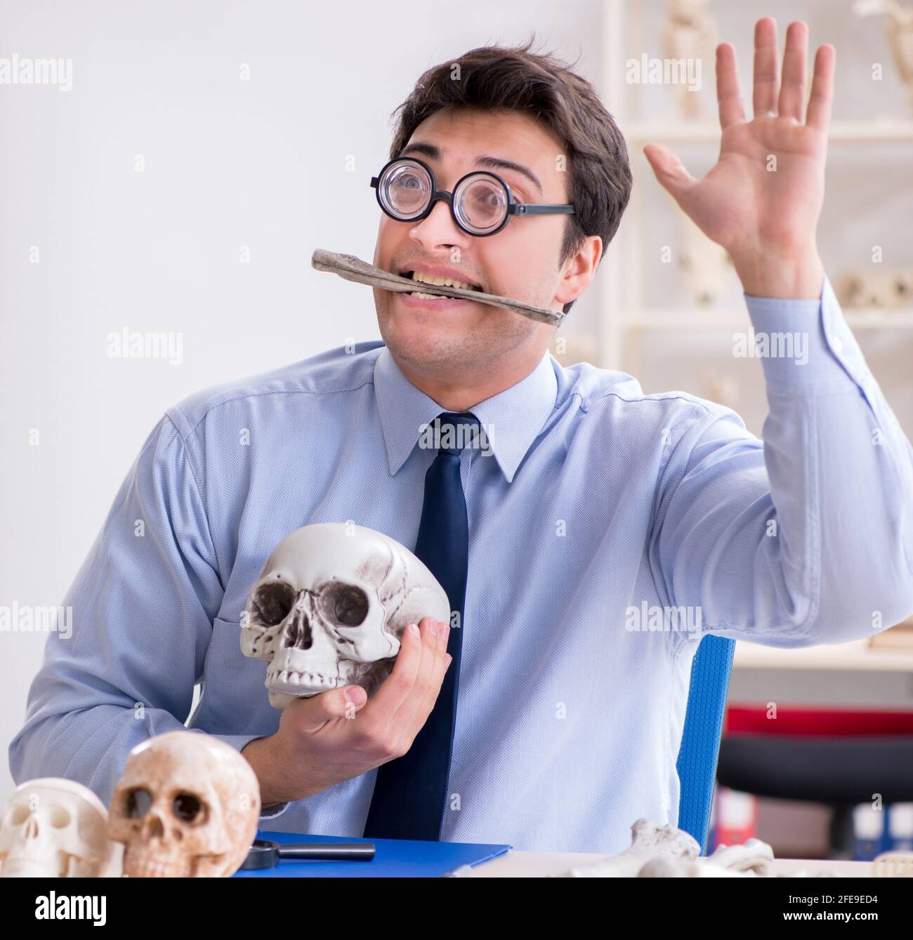 The funny crazy professor studying human skeleton Stock Photo - Alamy