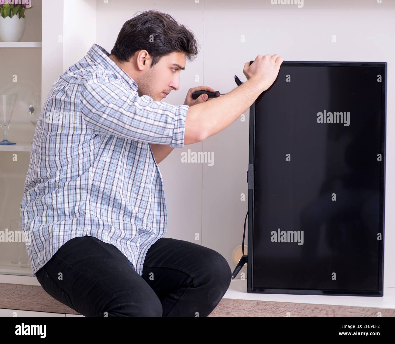 The man repairing broken tv at home Stock Photo - Alamy