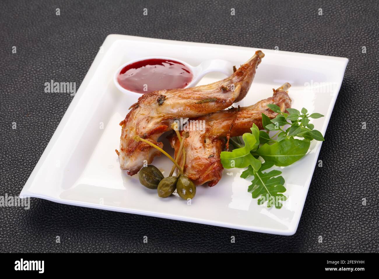 Roasted rabbit legs with cowberry sauce Stock Photo - Alamy