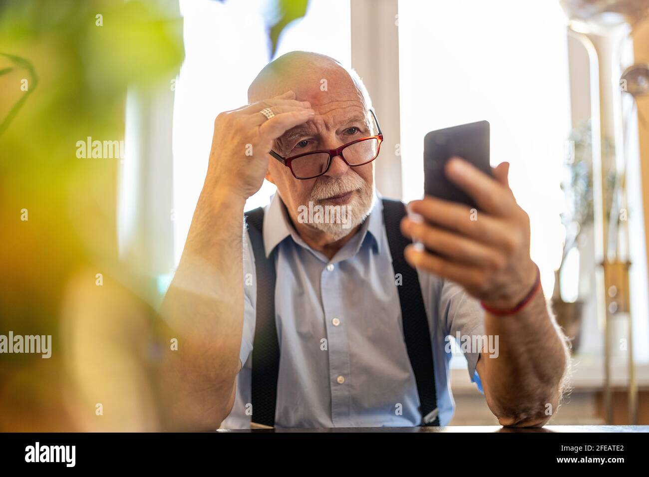 Shot of a senior man using a mobile phone at home Stock Photo - Alamy
