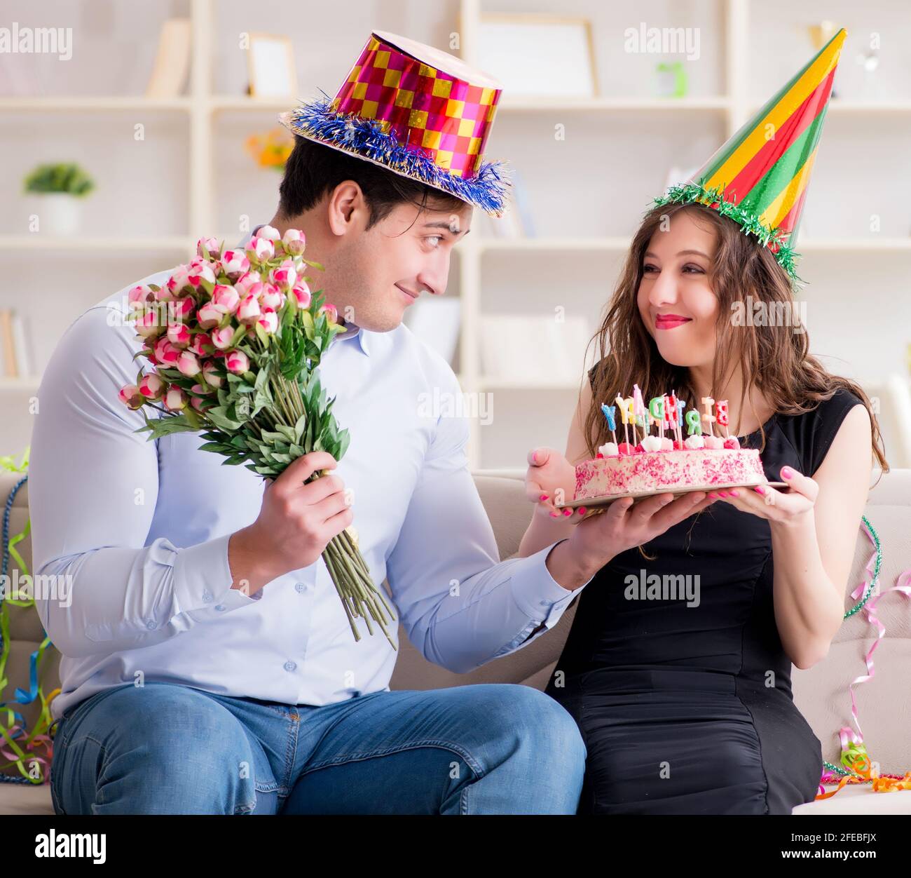 The young couple celebrating birthday with cake Stock Photo - Alamy