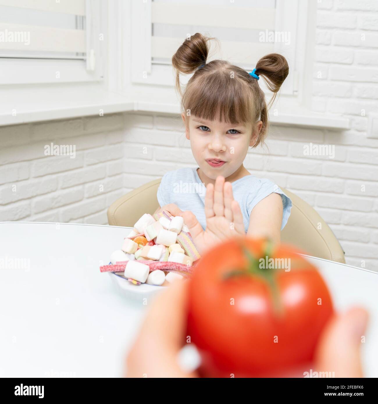 Cute little girl choosing between tomatoes and sweets, child rejects ...