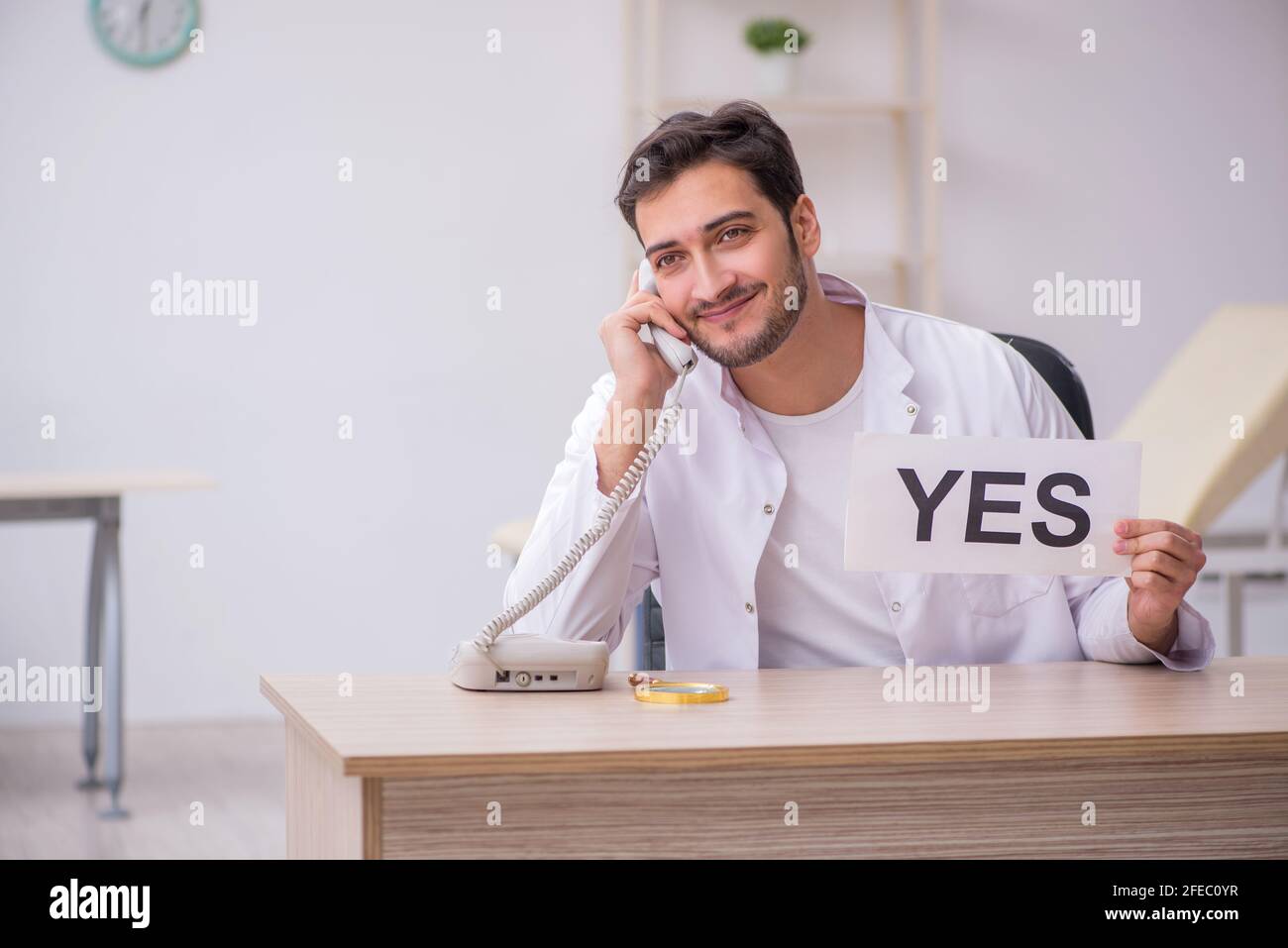 Young doctor cardiologist holding yes banner Stock Photo - Alamy
