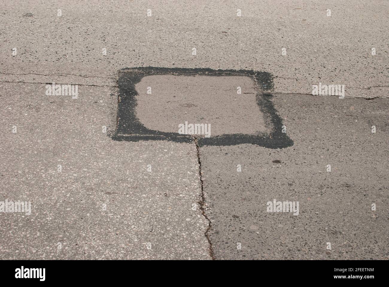 Cracked asphalt road surface and repair patch closeup Stock Photo - Alamy