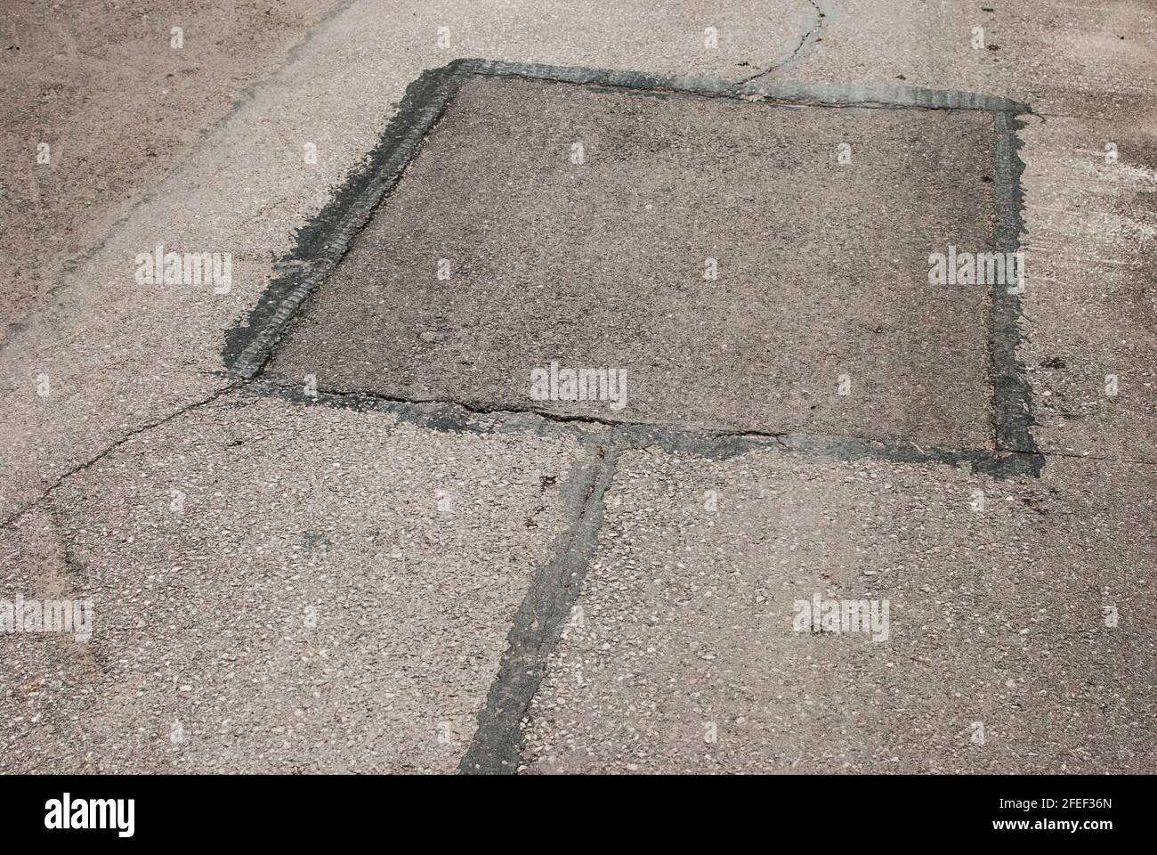 Cracked asphalt road surface and repair patch closeup Stock Photo - Alamy
