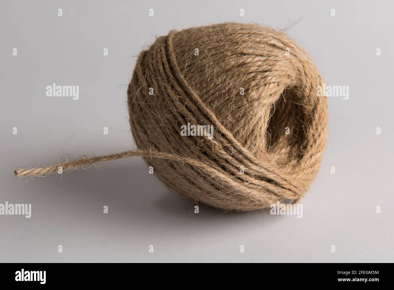 Roll of natural jute rope on white background Stock Photo - Alamy