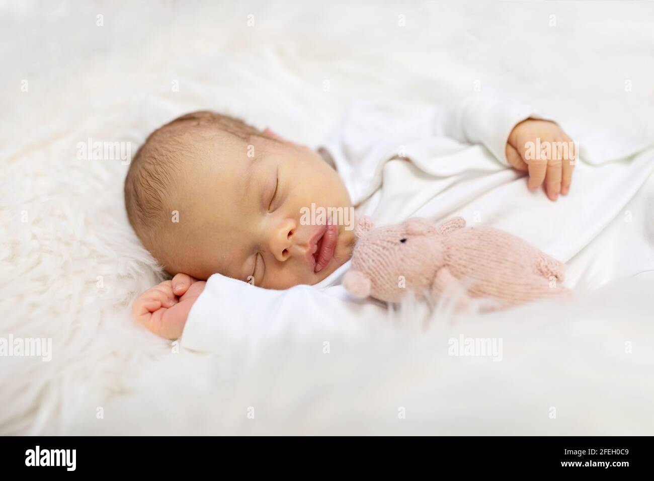Adorable newborn one week age in white bedroom. Newborn child relaxing ...