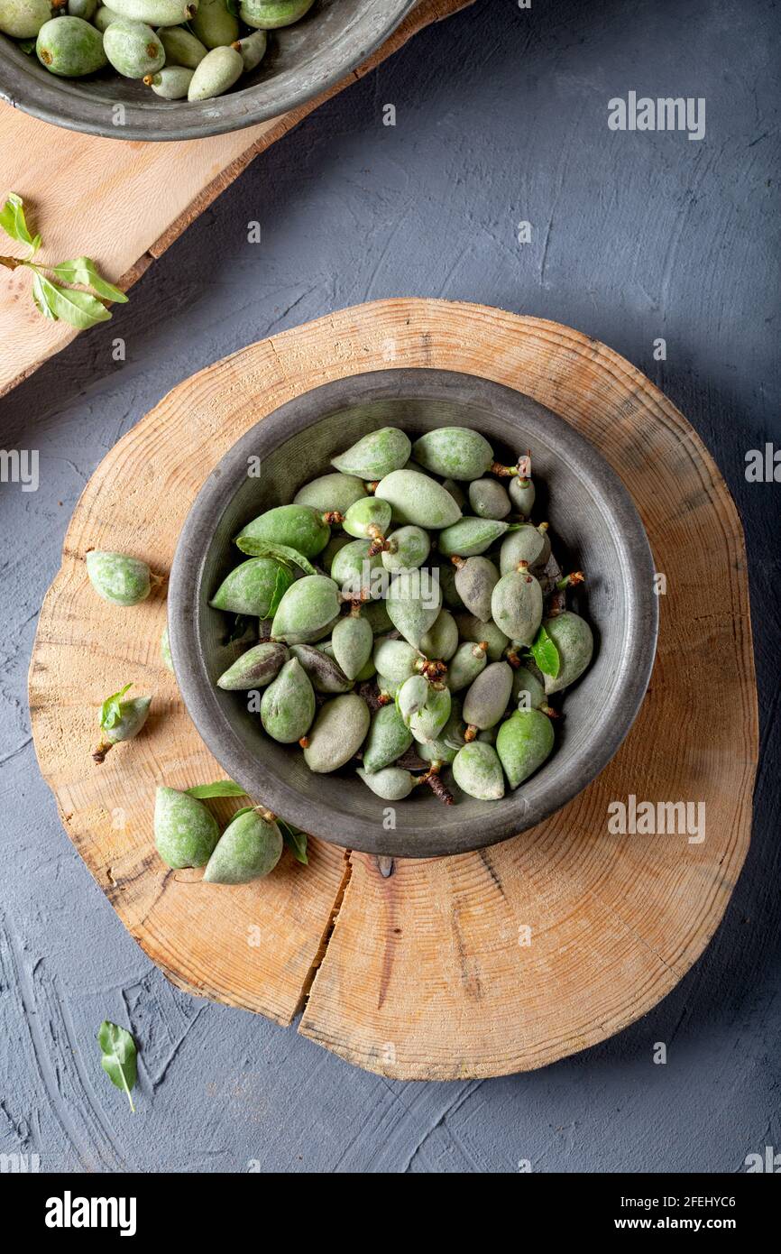 Bowl of fresh unripe almonds on gray background. Fresh raw green ...