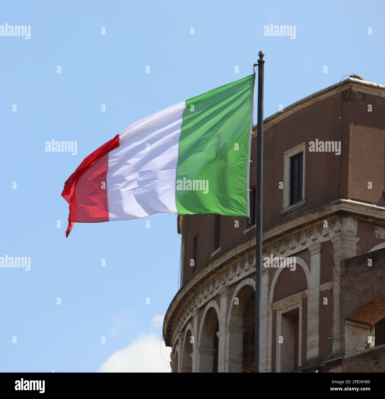 huge italian flag flying and the background of an ancient palace in ...