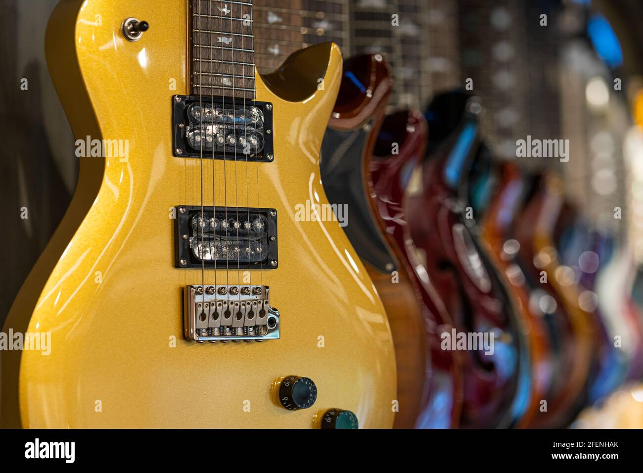 Row of electric guitars different color in a music instruments shop ...