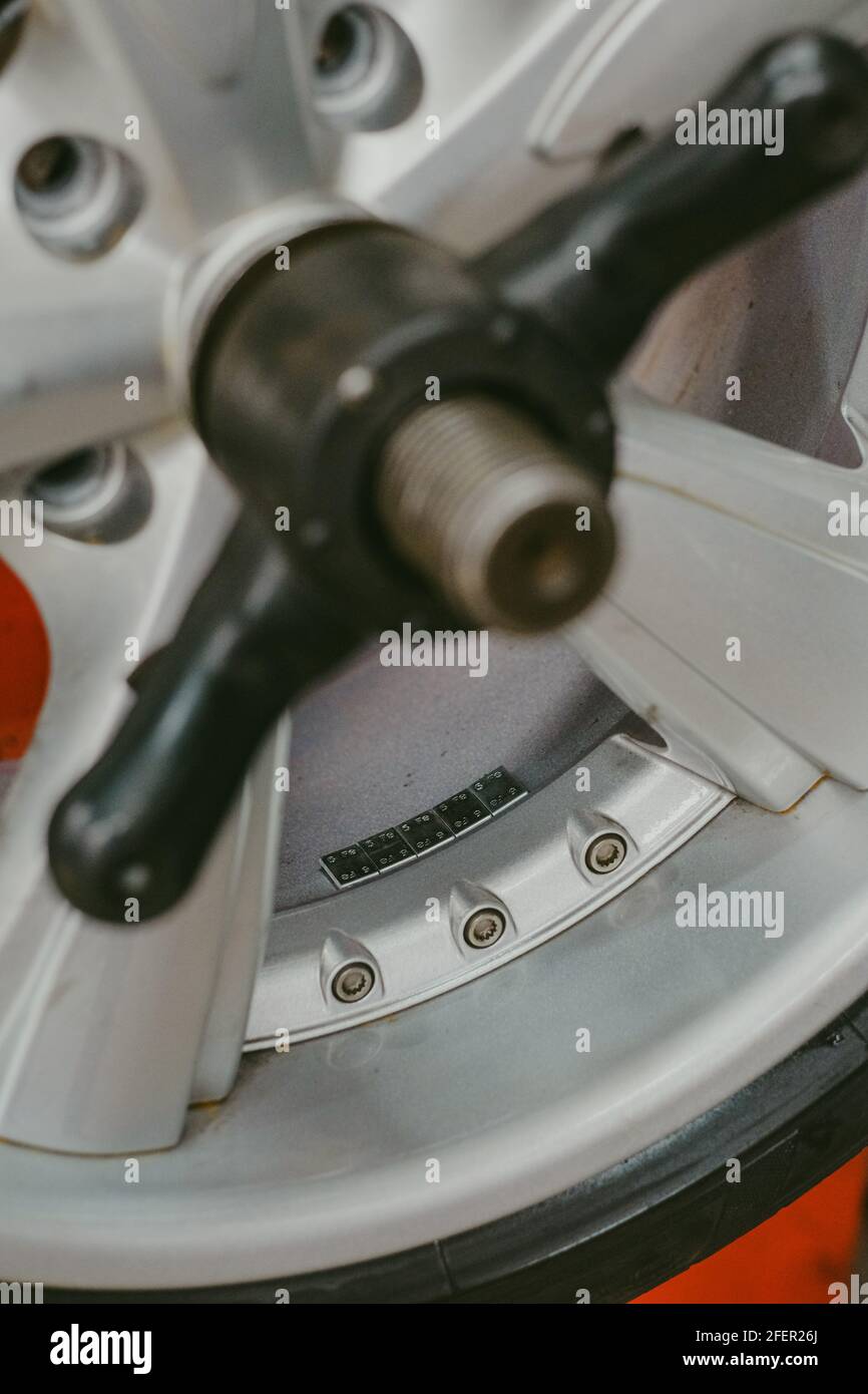 Vertical shot of the rim of a car tire being removed by a special tool ...