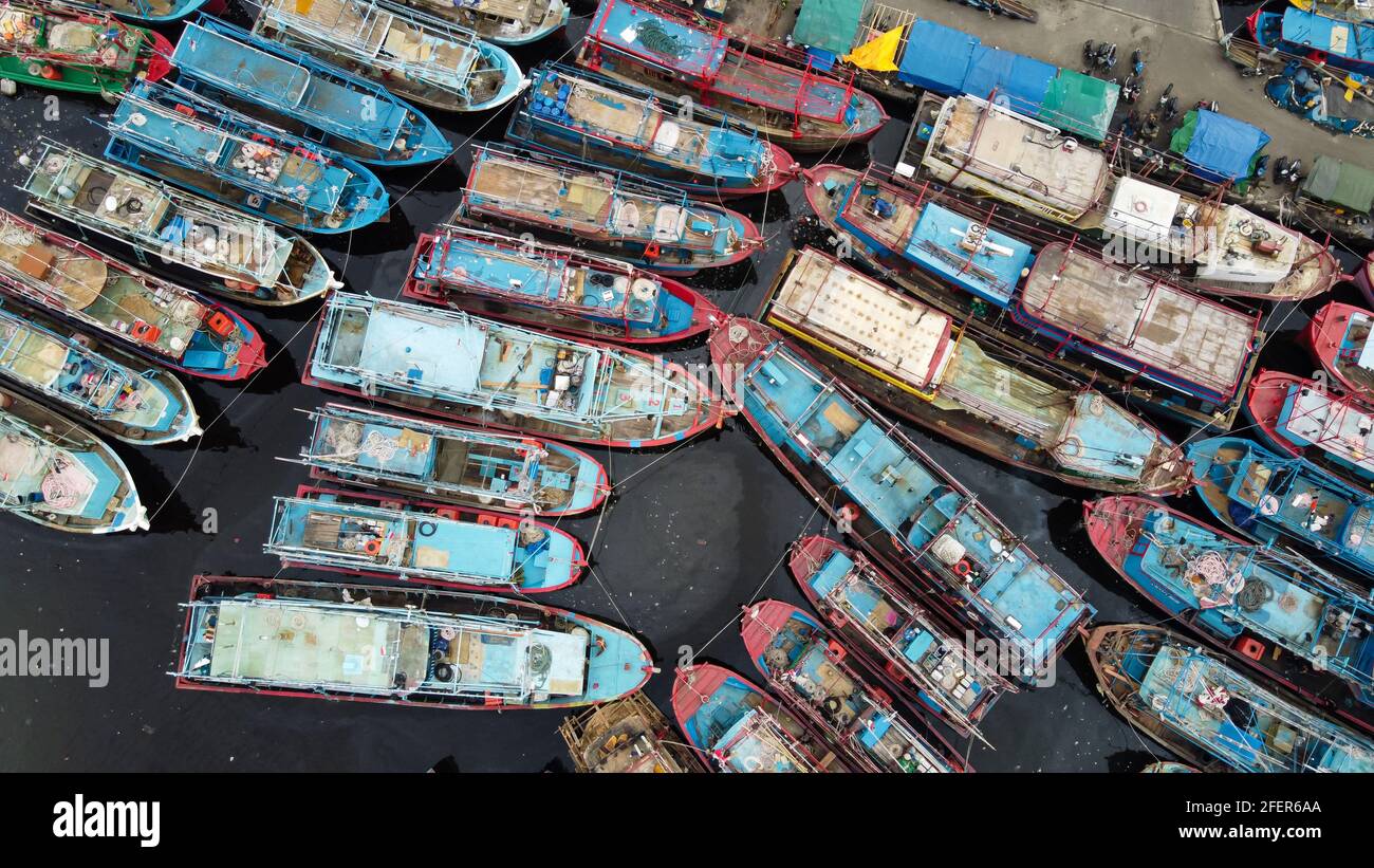 Aerial drone view of Muara Angke Beach with wooden boats leaning beside ...