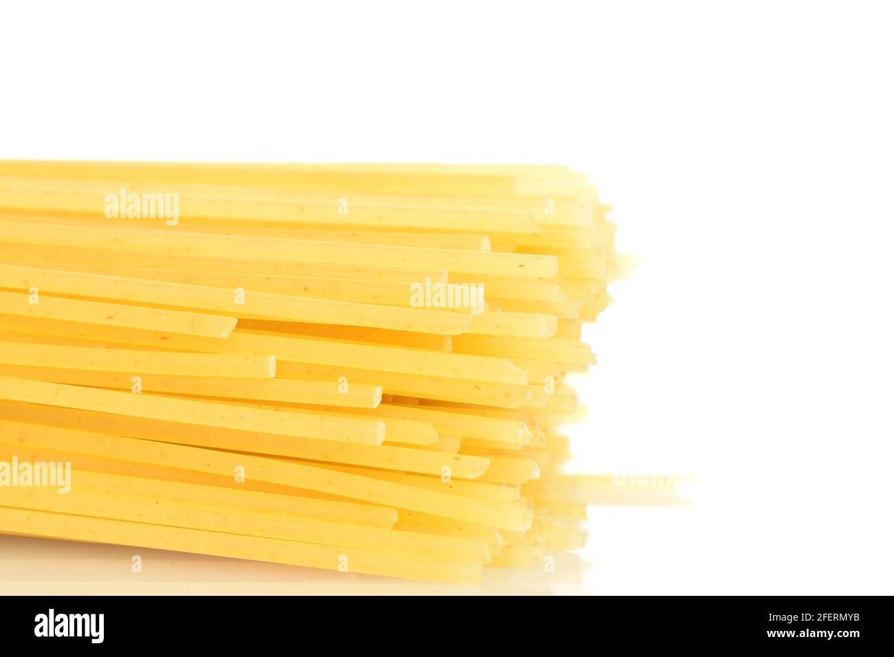 Uncooked bright yellow spaghetti, close-up, isolated on white Stock ...