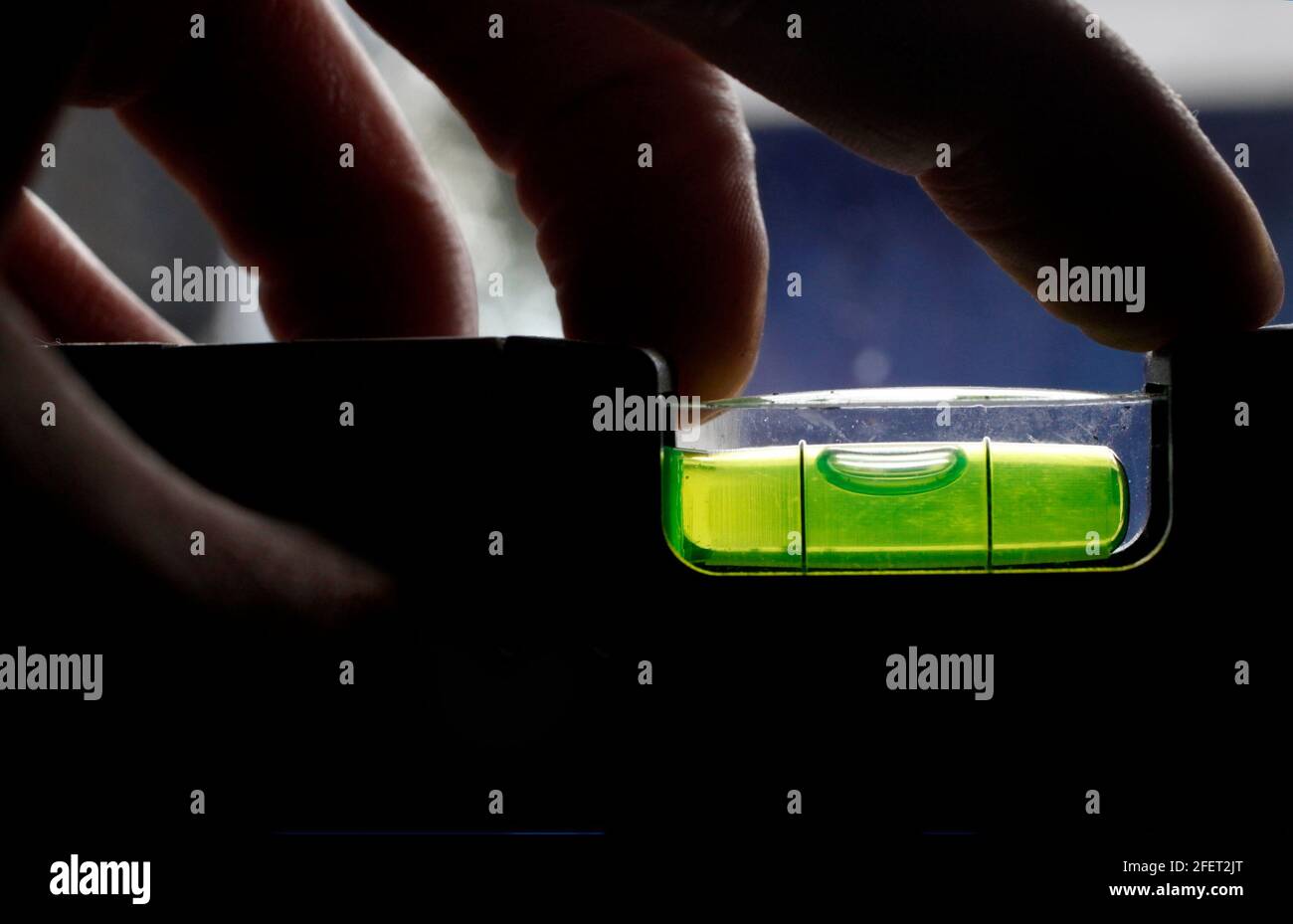 Someone who holds a spirit level on a construction site Stock Photo - Alamy
