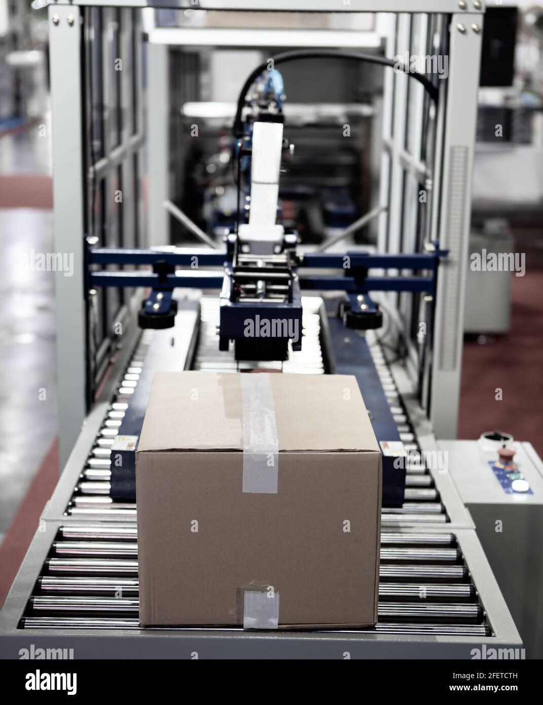 Carton on roller conveyor. Automatic carton tape sealing machine ...