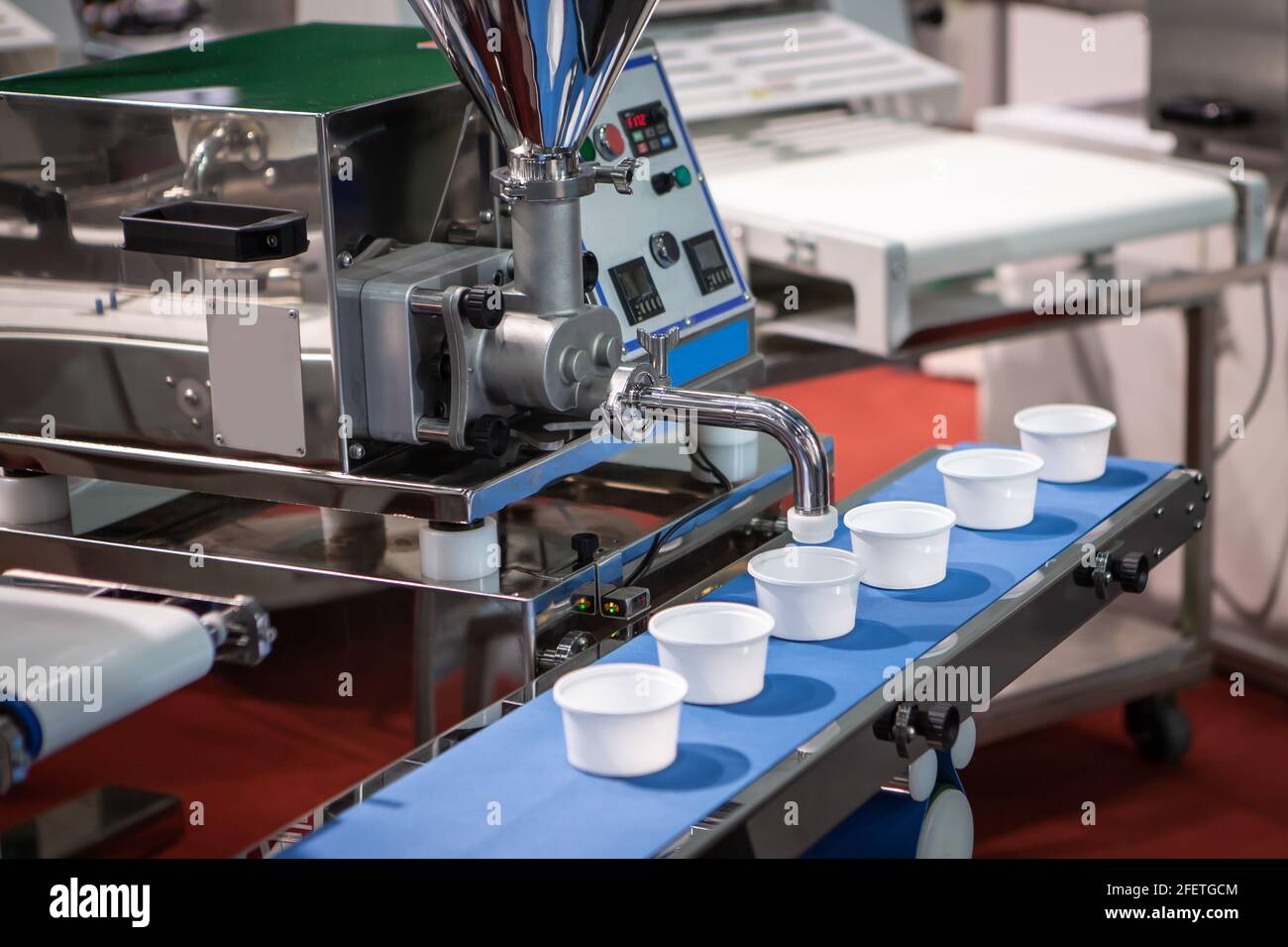 Cream filling machine in bakery processing. Food depositor machine ...