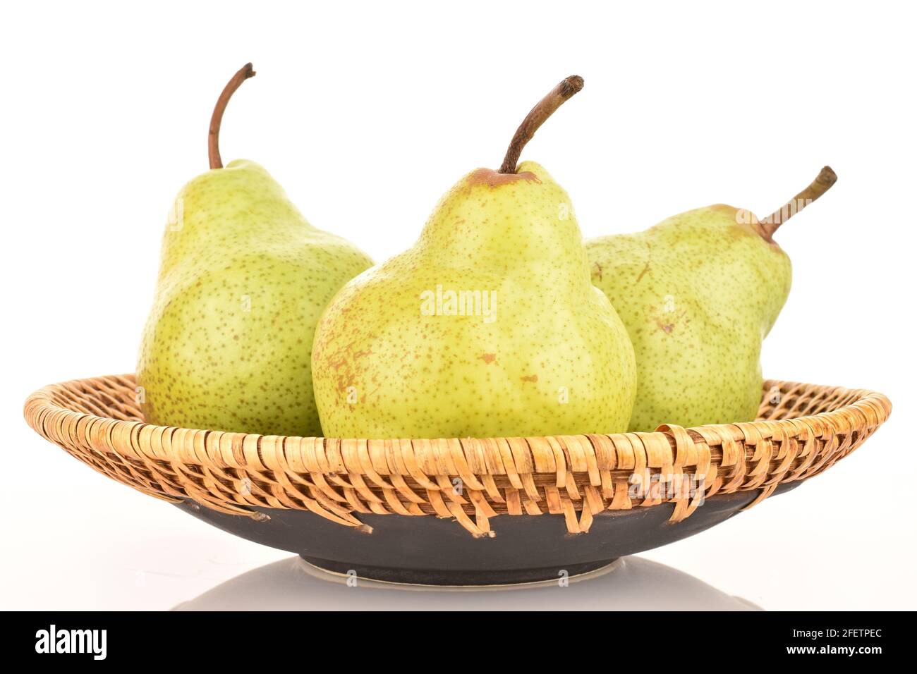 Three green juicy pears, in a plate, close-up, on a white background ...
