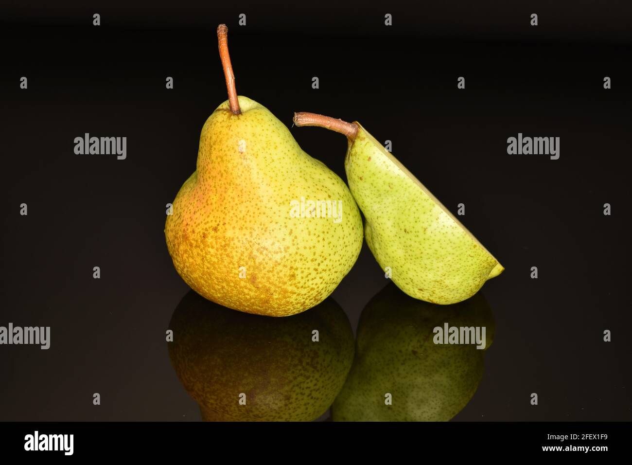 One whole and one half of organic green pear, close-up, isolated on ...