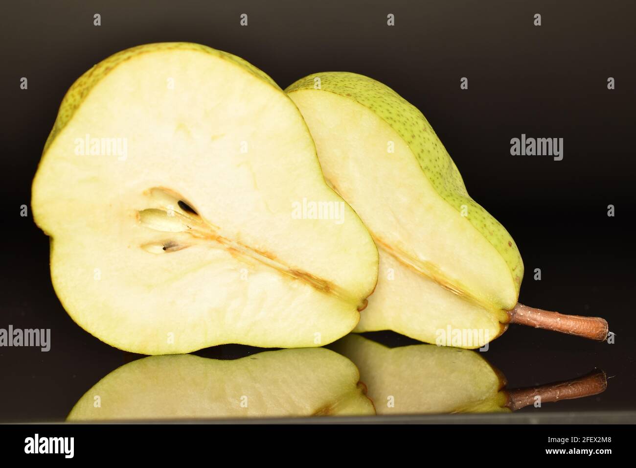 Two half, in focus, sweet pears on a black background Stock Photo - Alamy