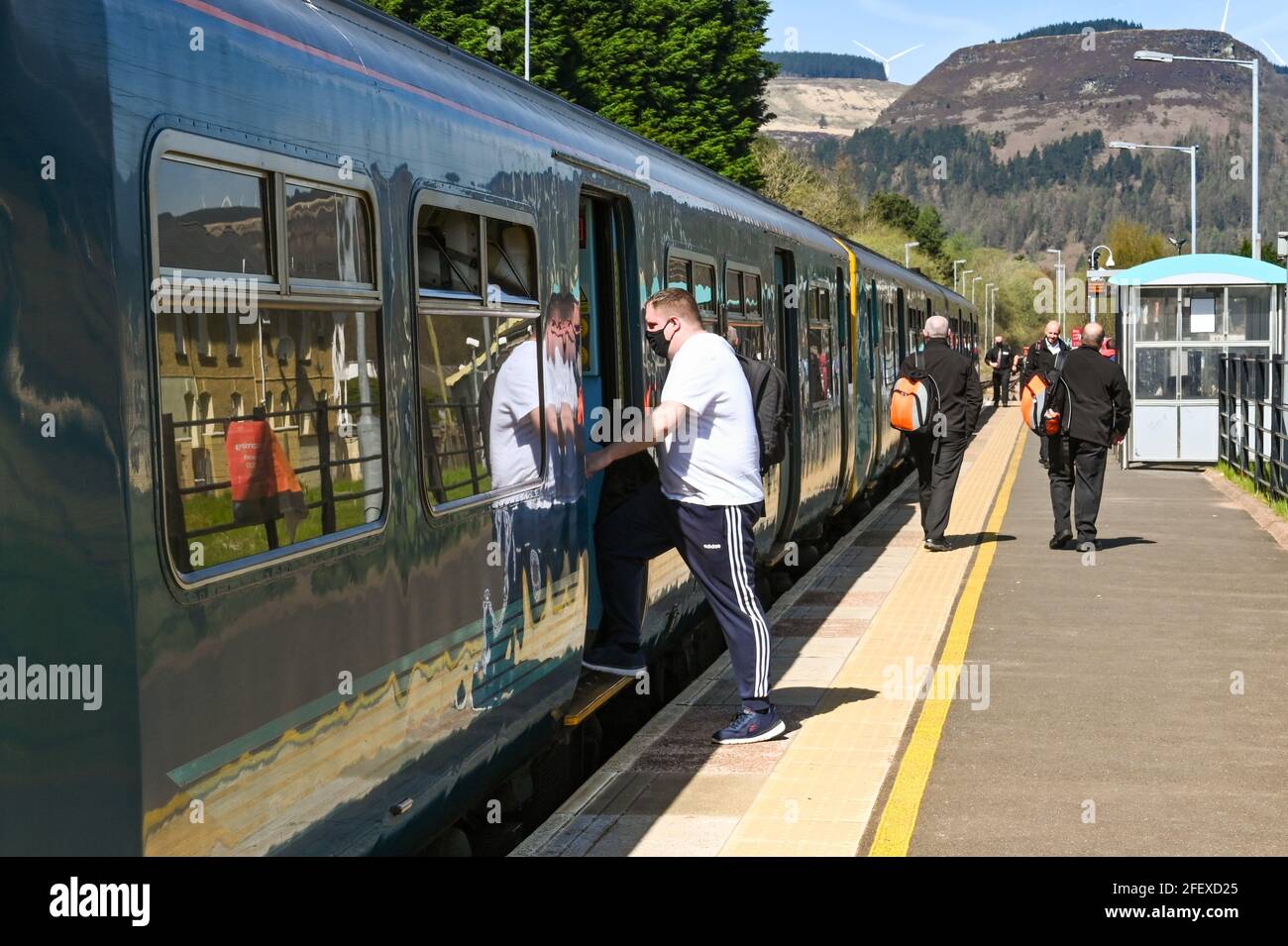 Treherbert, Rhondda Valley, Wales - April 2021: Person catching a train ...