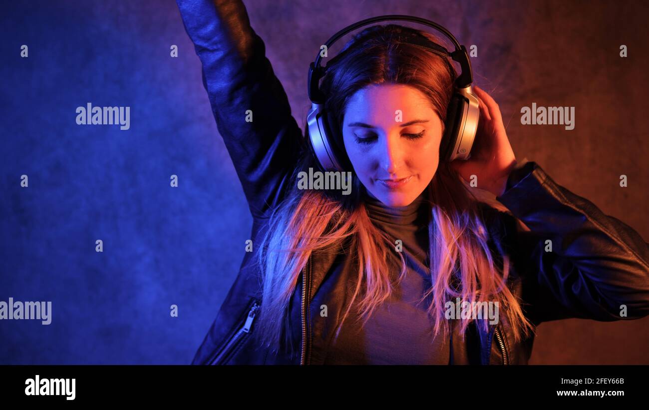 Pretty girl dancing to music - colorful portrait shot Stock Photo - Alamy