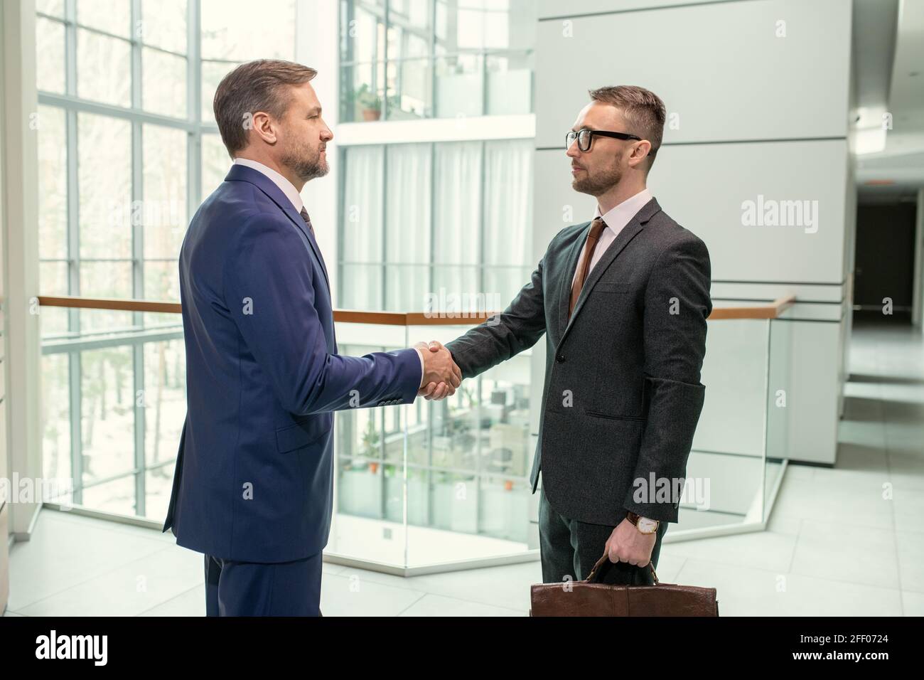 Two men in suits holding hands hi-res stock photography and images - Alamy