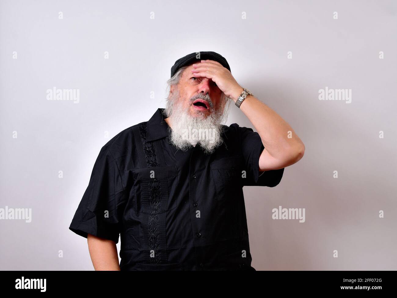 View of an elderly man holding his forehead as a sign of distress on a ...