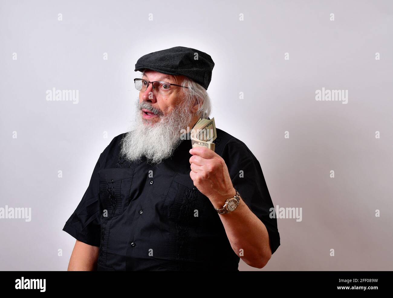 View of an elderly man fanning himself with a handful of banknotes on a ...