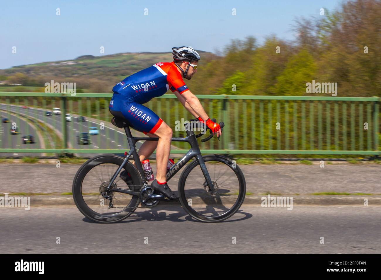 Male cyclist riding Giant sports road bike, blurred, low shutter speed ...