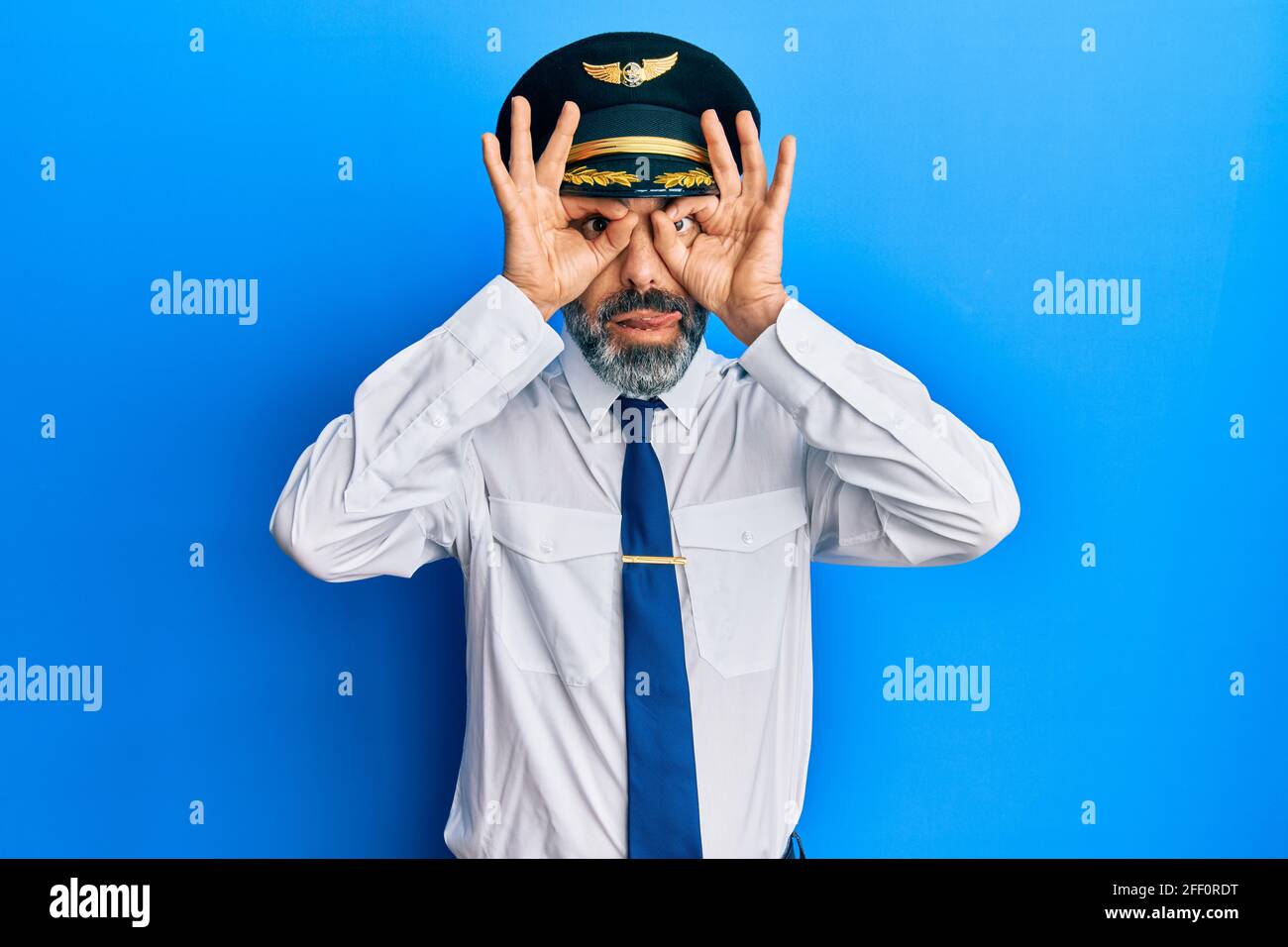 Middle age man with beard and grey hair wearing airplane pilot uniform ...
