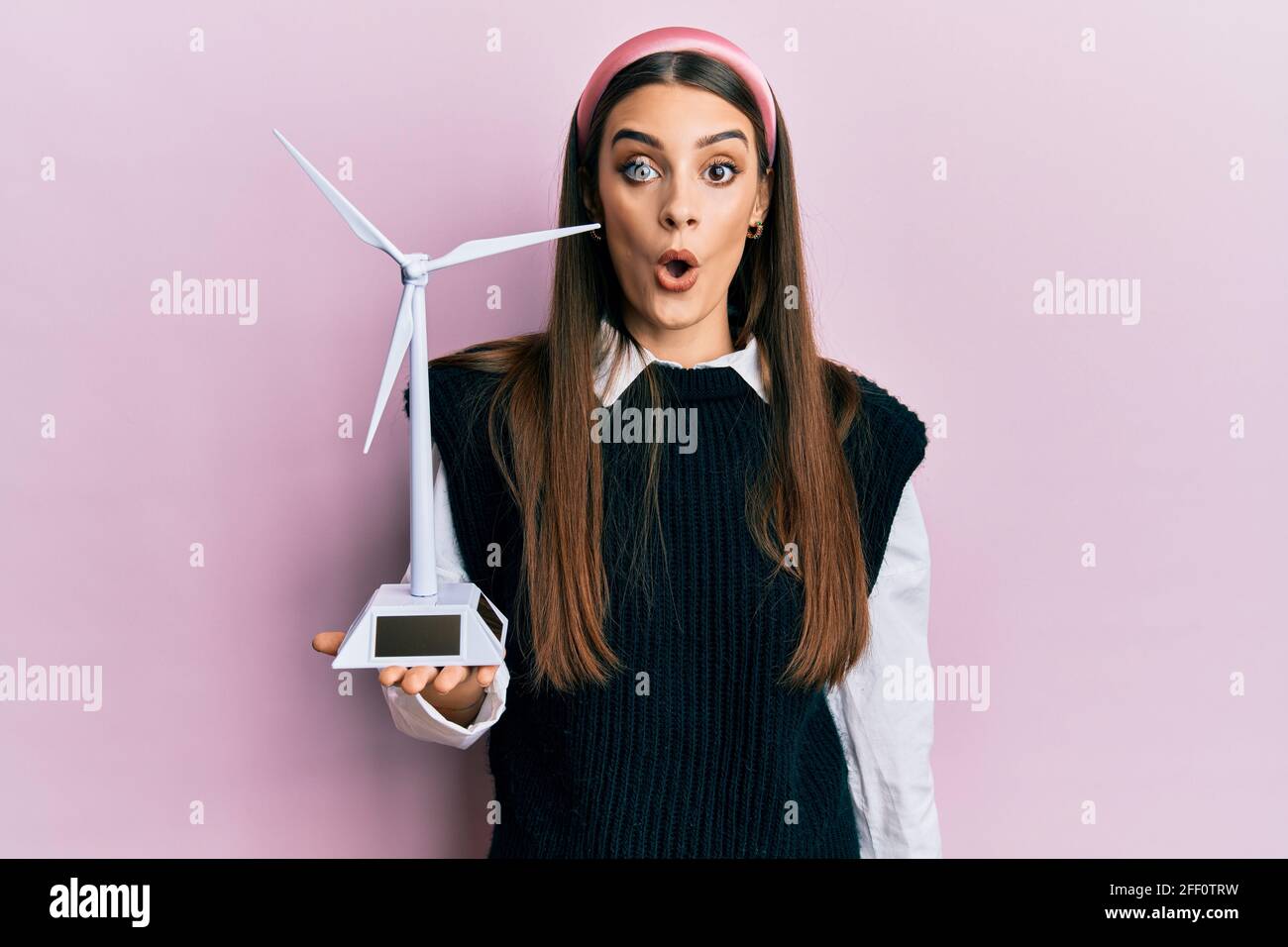 Beautiful brunette young woman holding solar windmill for renewable ...