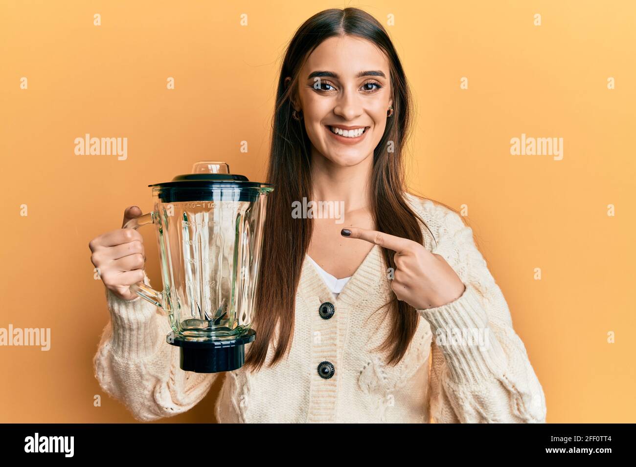 Beautiful brunette young woman holding food processor mixer machine ...